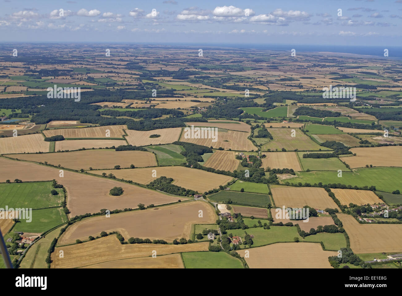 Aerial view of farmland with arable fields, hedgerows and woodland ...