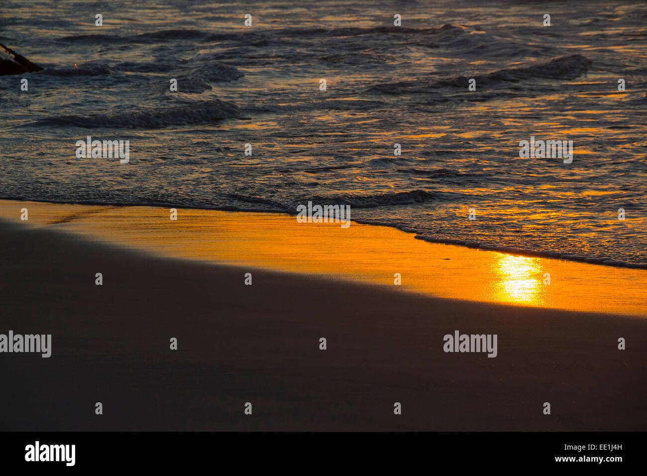 Golden reflection on beach sand after wave crashed Stock Photo - Alamy