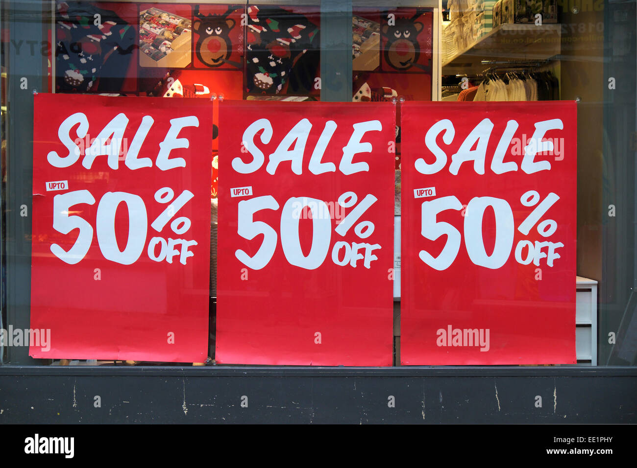 Sale signs in a shop window in a high street in a town in England in ...