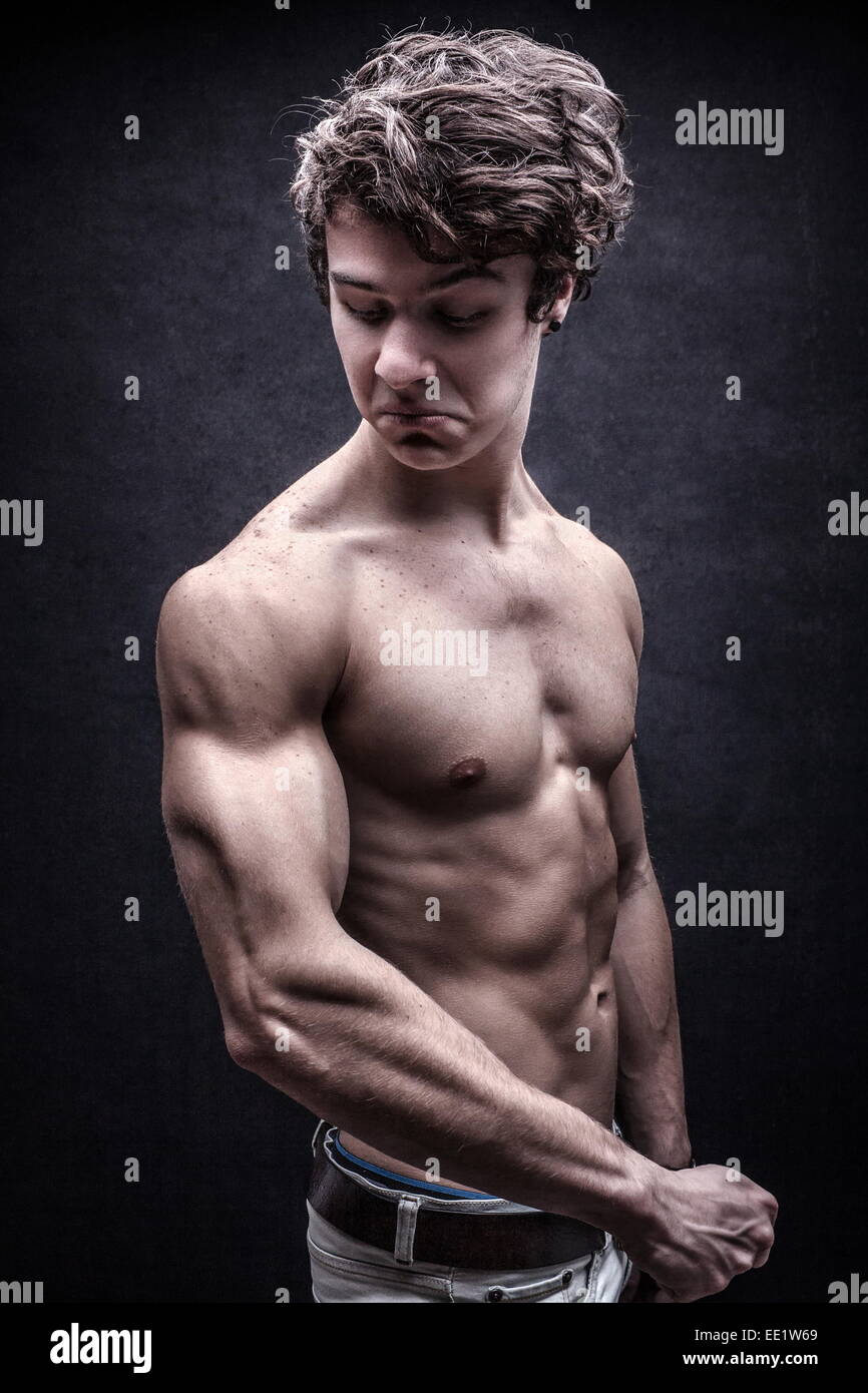 Strong young man looked down dissatisfied to his arm muscles Stock ...