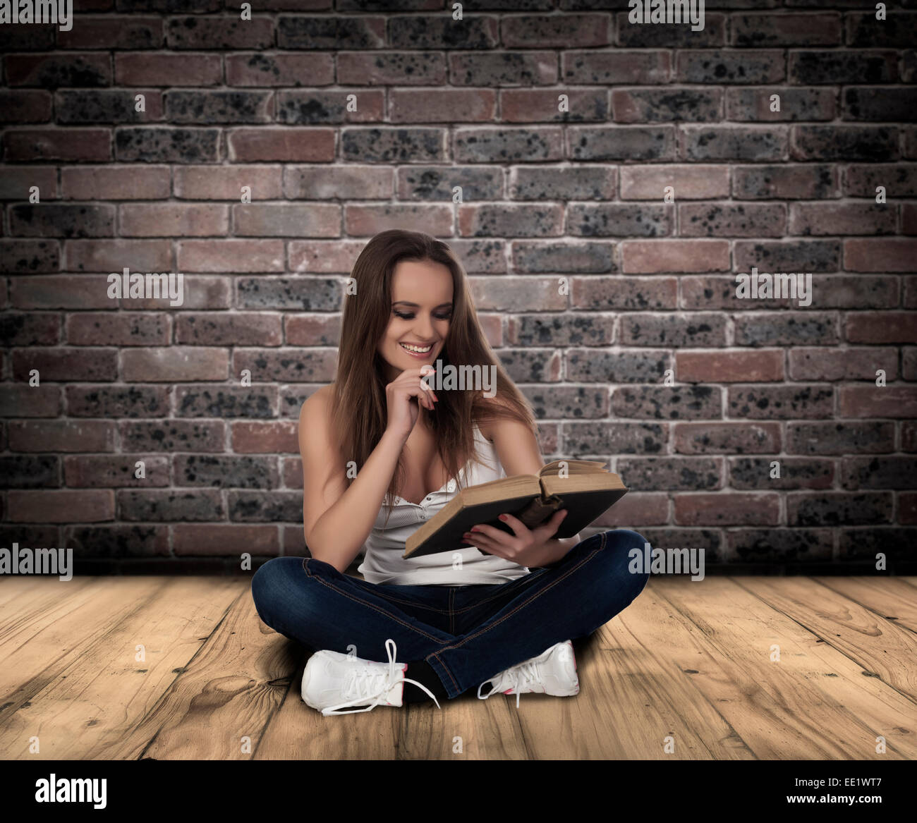 Young beautiful woman reading a book while sitting on the floor Stock ...