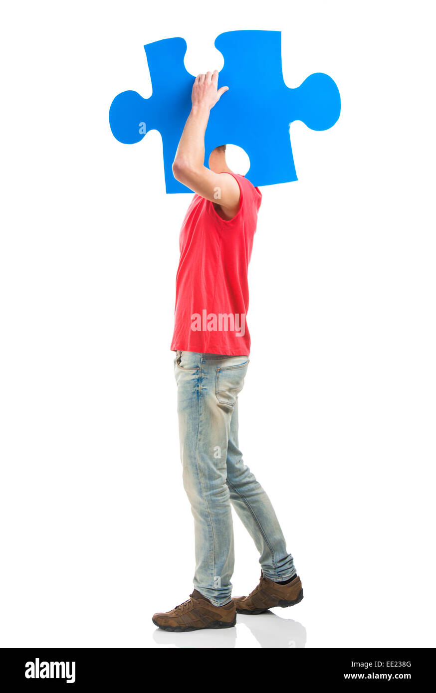 Good looking young man holding a blue puzzle piece, isolated on a white ...