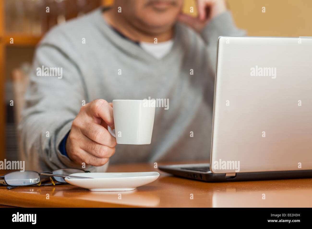 man on laptop with cup Stock Photo - Alamy