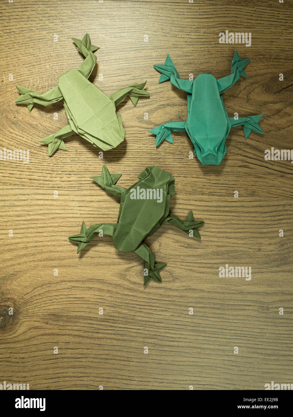 Green origami frogs on wooden surface Stock Photo - Alamy