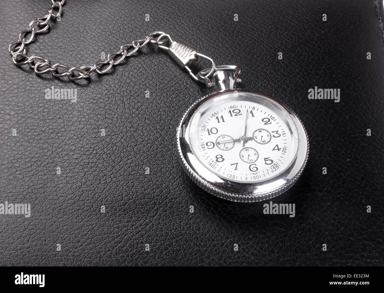 An open pocket watch on leather wallets Stock Photo - Alamy