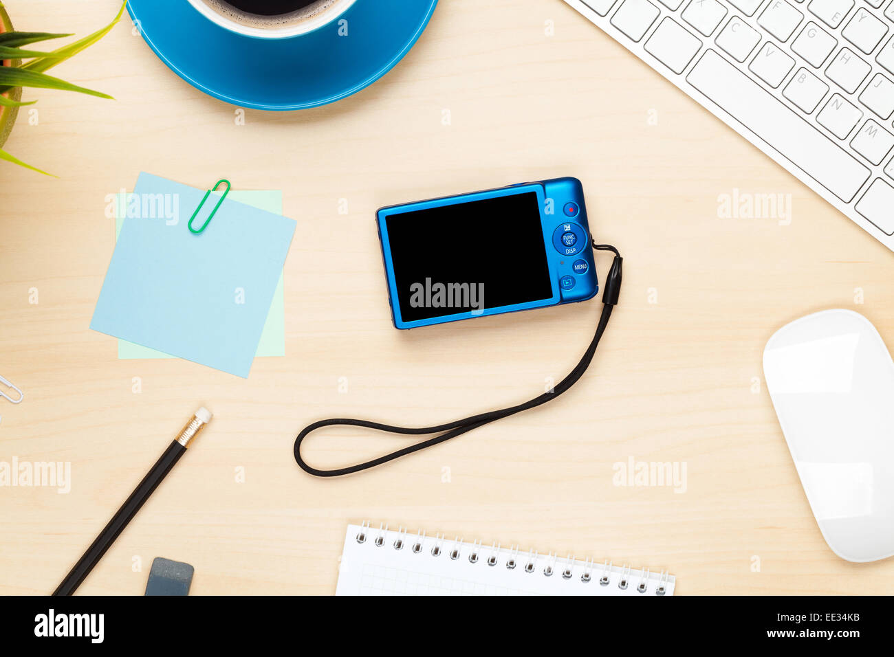 Photo camera on office table with notepad, computer and coffee cup ...