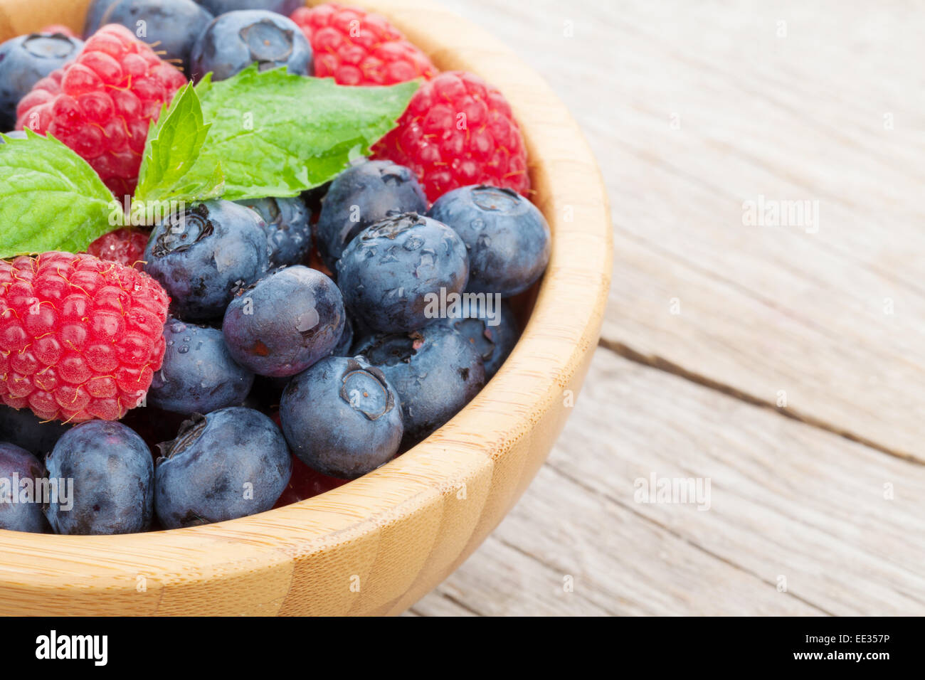 Blueberries and raspberries bowl on wooden table with copy space Stock ...