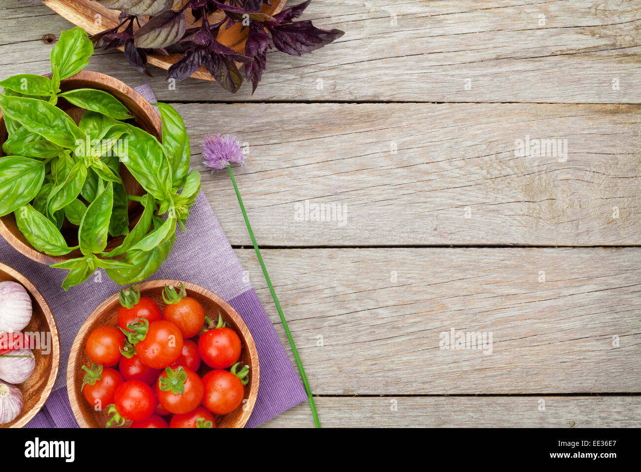 Fresh farmers tomatoes and basil on wood table. View from above with ...