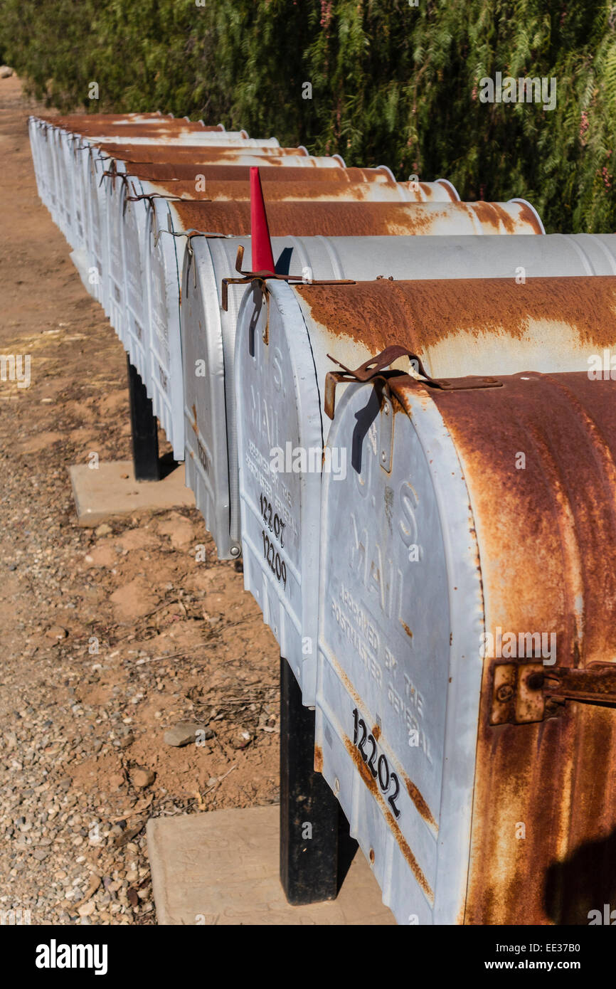 A row of identical rusting metal boxes along a country road outside of ...