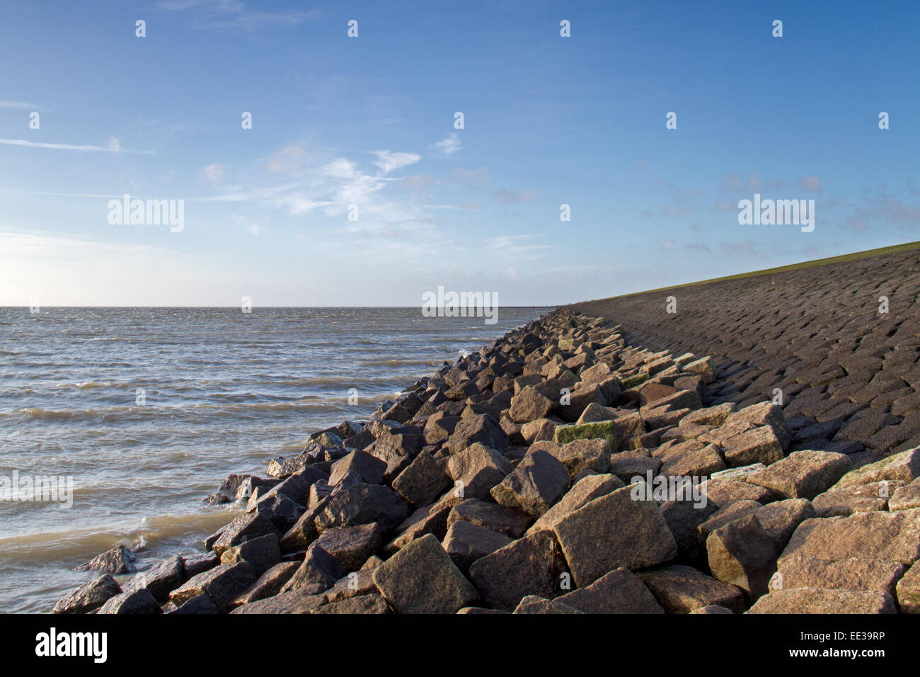 Solid dike of rocks and boulders on the coast of the Wadden sea in the ...