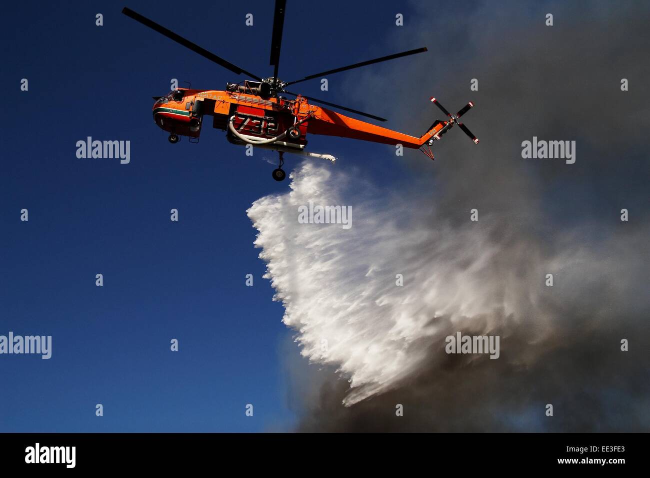 Helicopter drops water to fire Stock Photo - Alamy