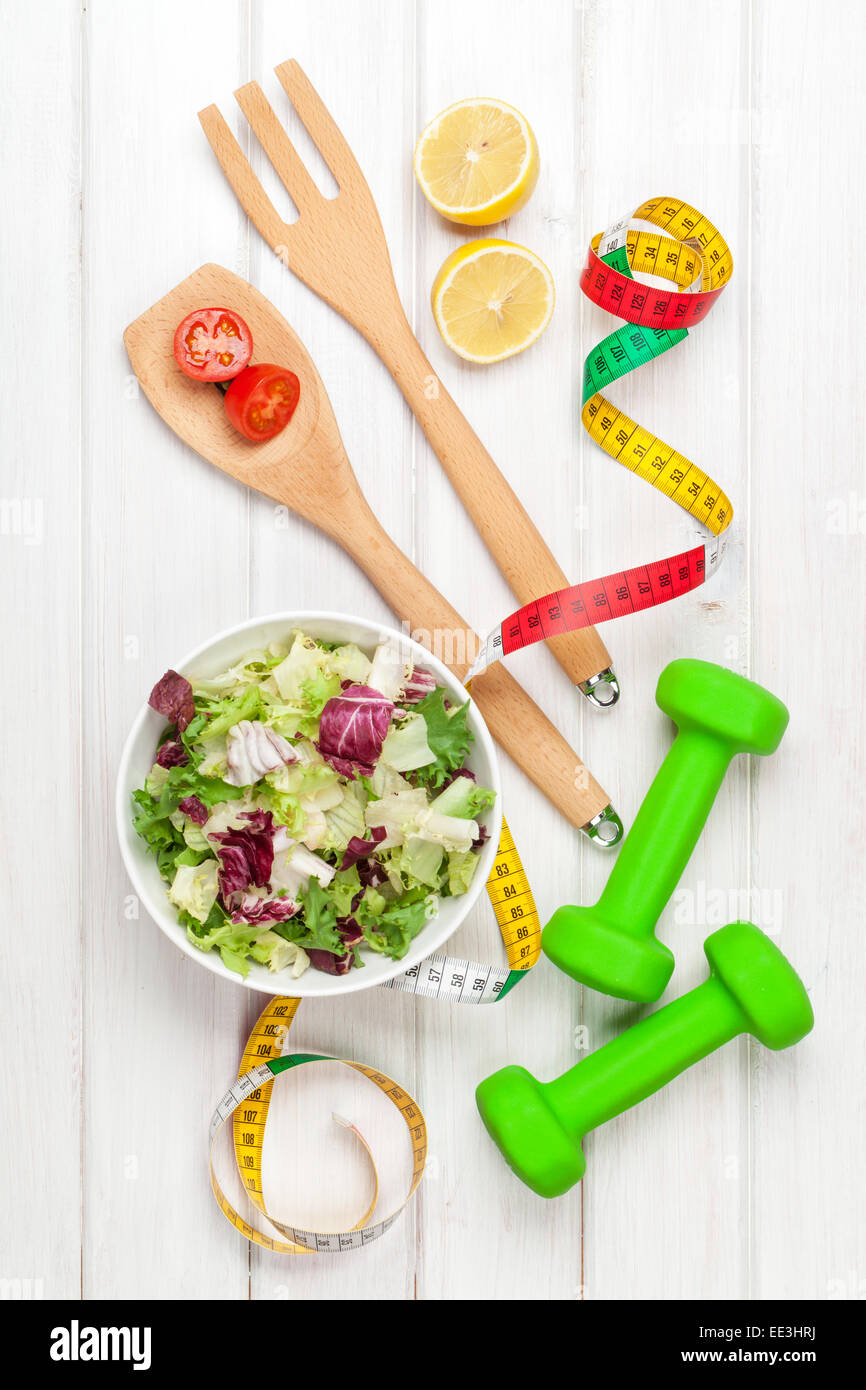 Dumbells, tape measure and healthy food. Fitness and health. View from ...