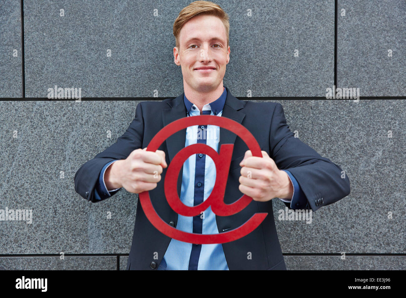 Business man holding red at sign as symbol for internet and email Stock ...