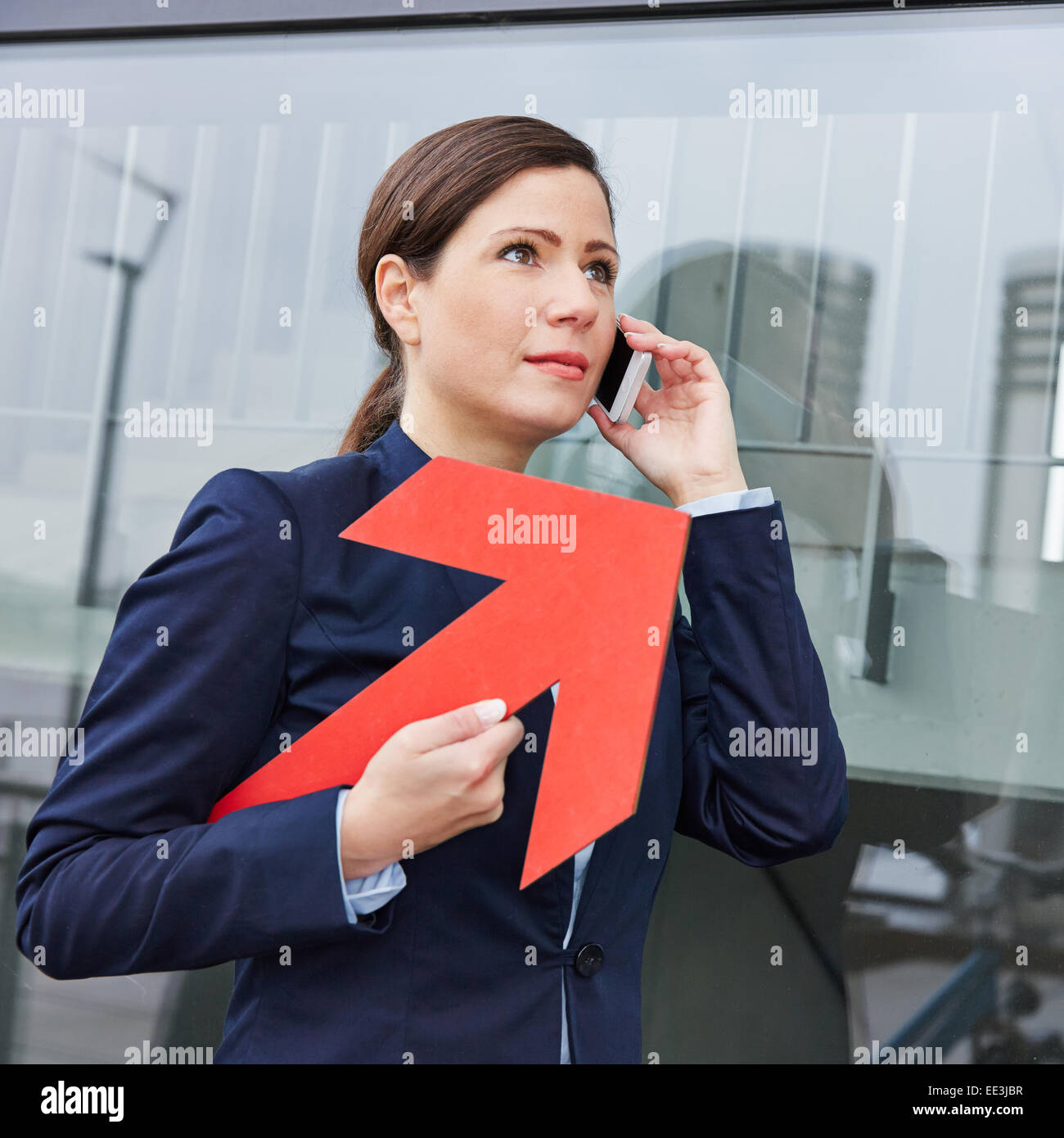 Business woman holding red arrow making phone call with her smartphone ...