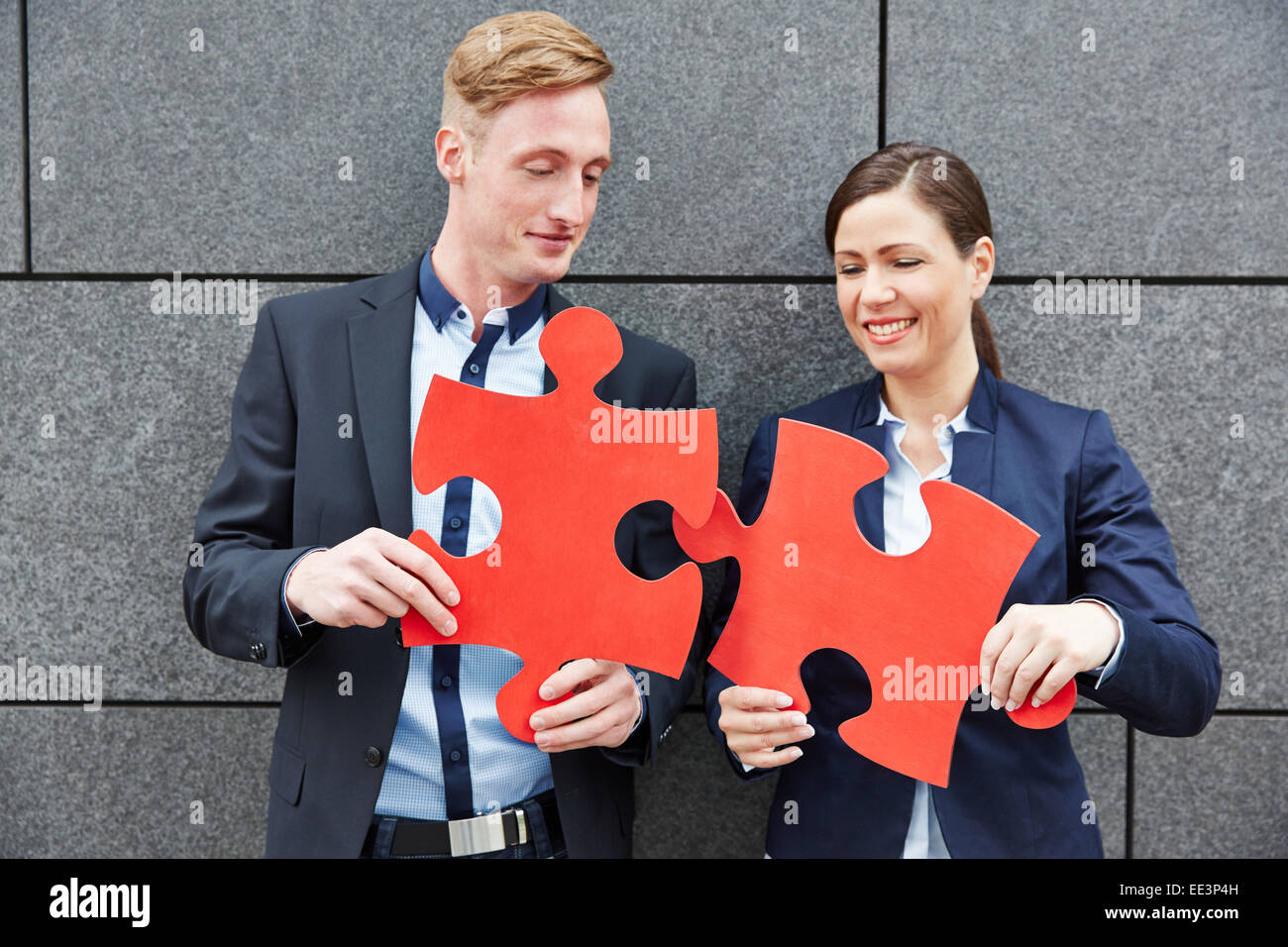 Two business people solving big red jigsaw puzzle pieces Stock Photo ...
