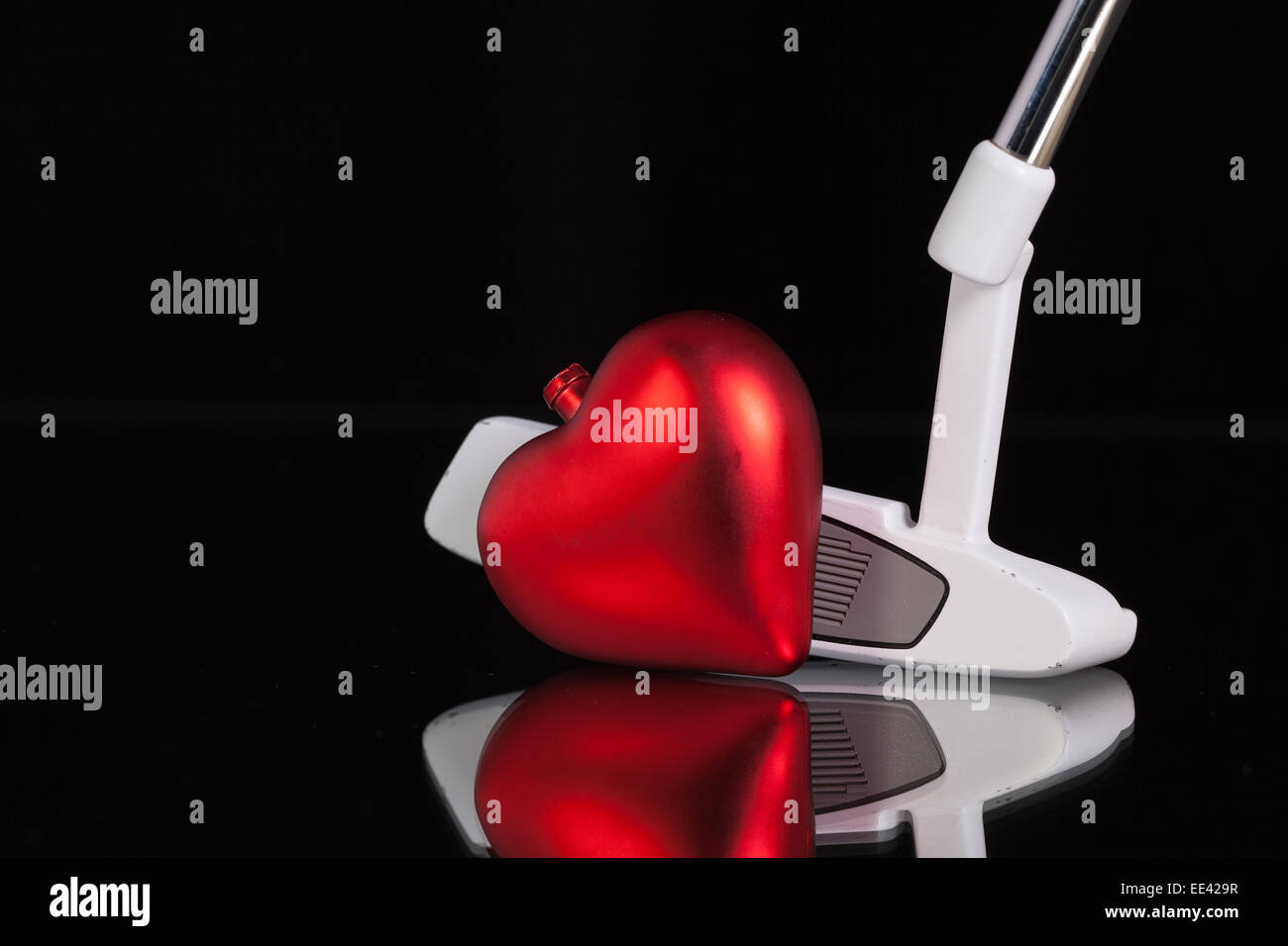 Golf putter and red heart on the black glass desk Stock Photo - Alamy
