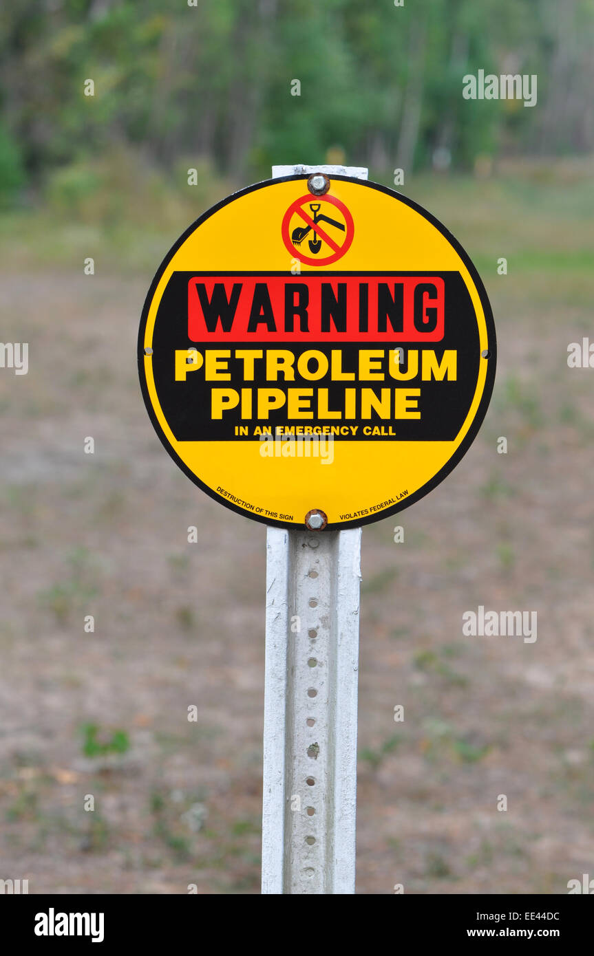 A red, black and yellow sign on a post reading Warning Petroleum ...