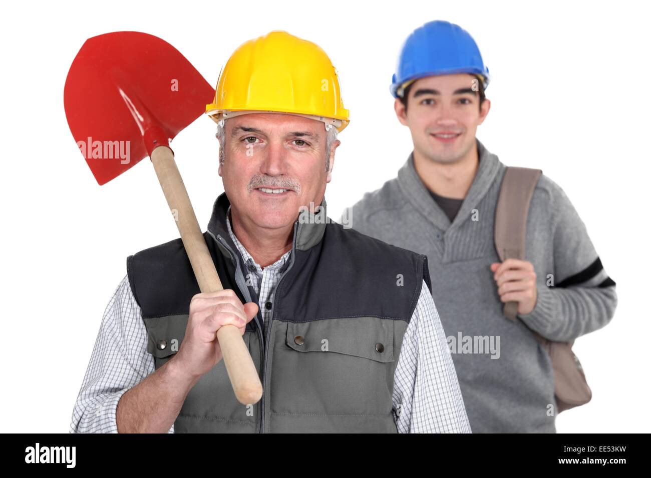 Experienced tradesman standing with apprentice Stock Photo - Alamy