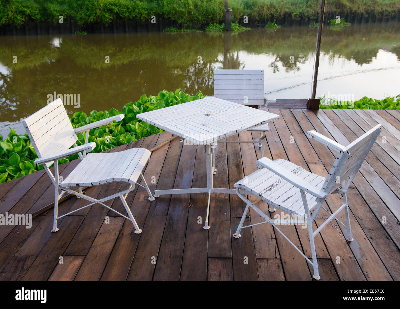 Garden chair and table with riverside Stock Photo - Alamy