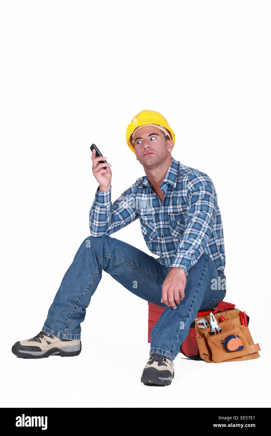 Tradesman fed up with his ringing phone Stock Photo - Alamy