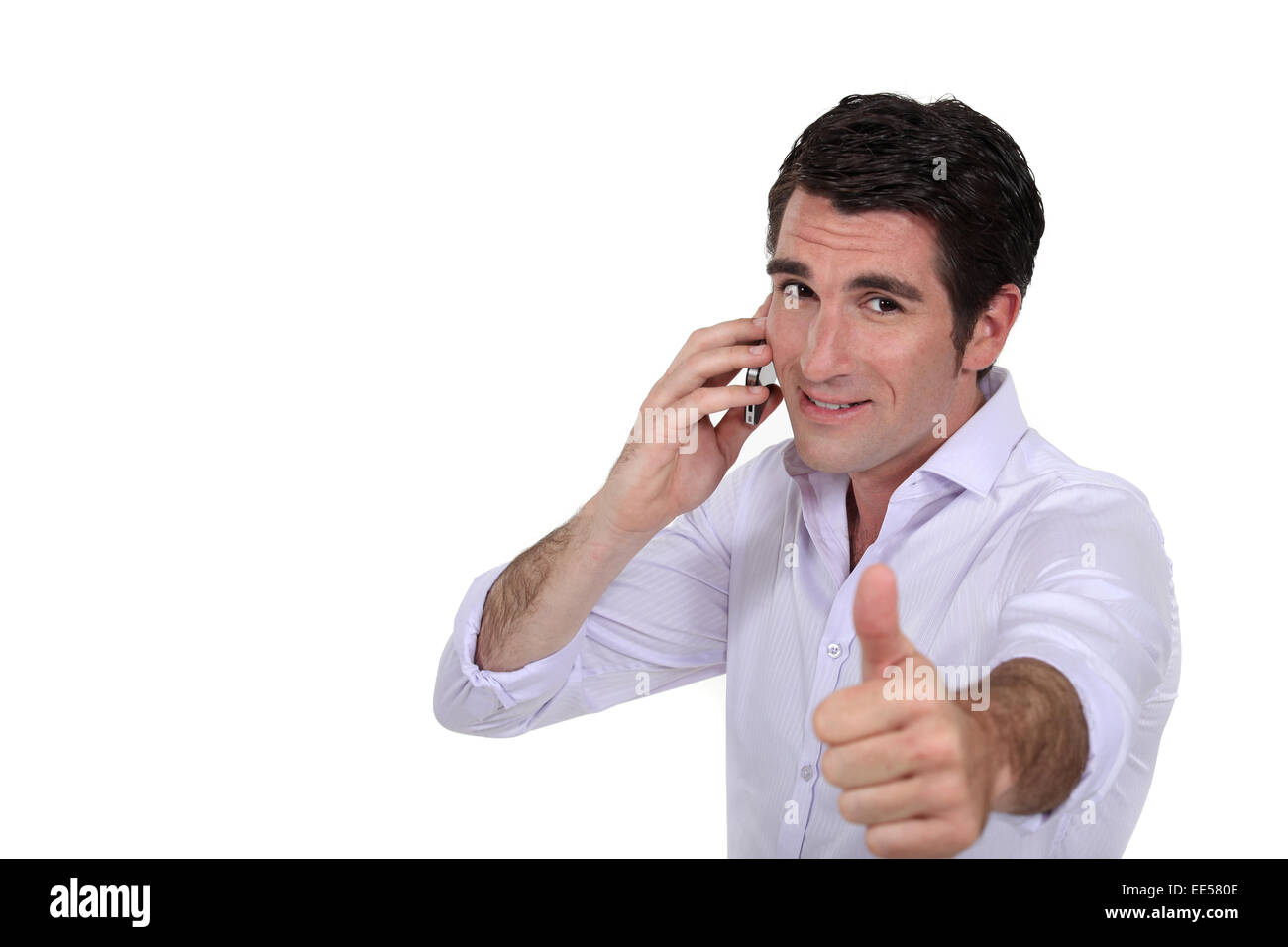Businessman giving the thumbs-up during phone call Stock Photo - Alamy