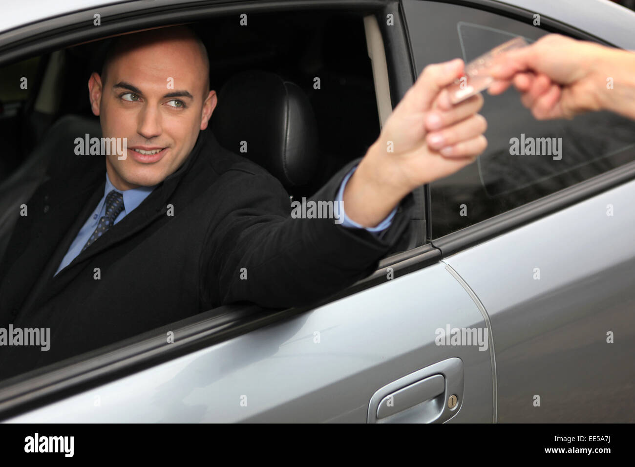 Man in a car using a credit card Stock Photo - Alamy