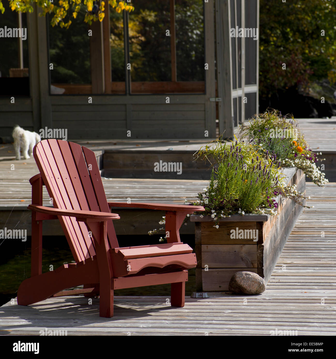 Adirondack chair and planter on a dock, Lake of The Woods, Ontario ...