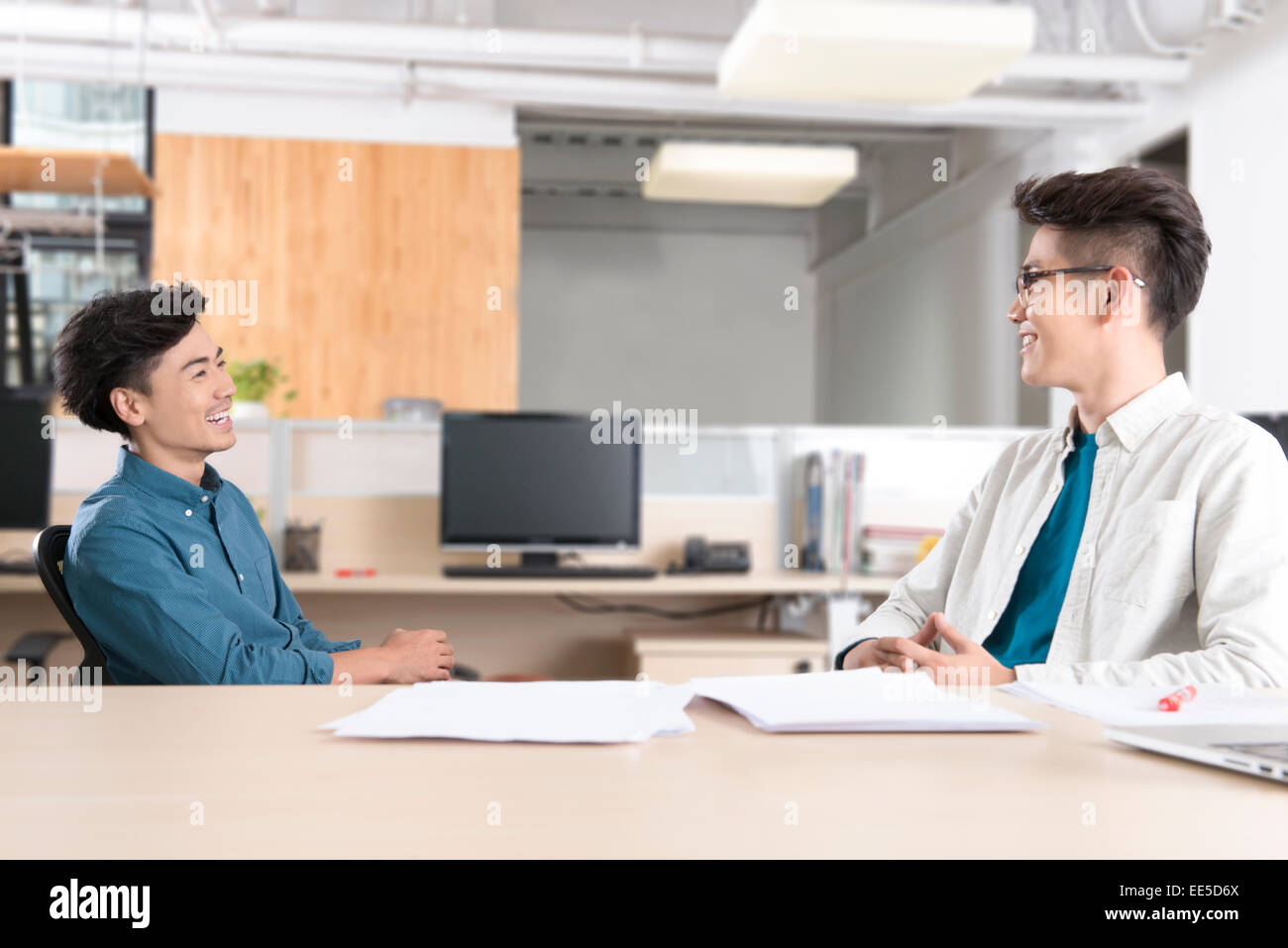 Creative workers talking in office space Stock Photo - Alamy
