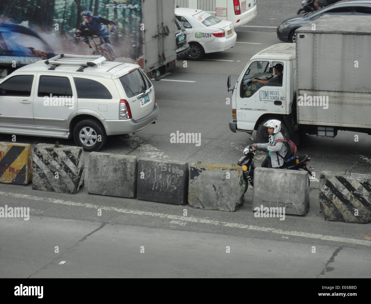 A Filipino motorcycle driver prepares to leave after stopping along ...