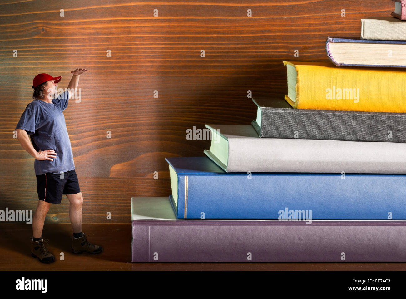 climber climbs a heap of books, composite image Stock Photo - Alamy
