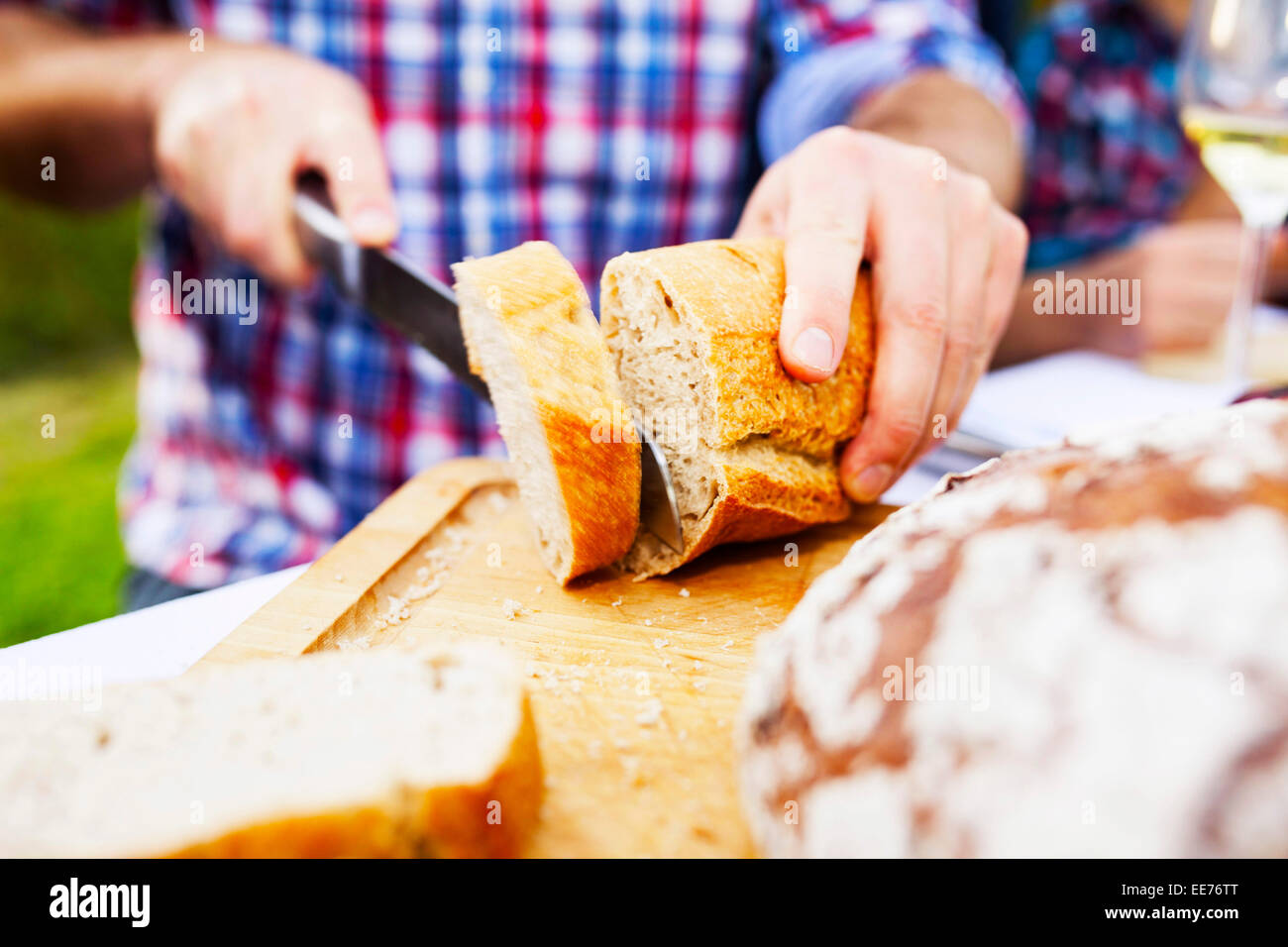 Hand cutting bread knife hi-res stock photography and images - Alamy