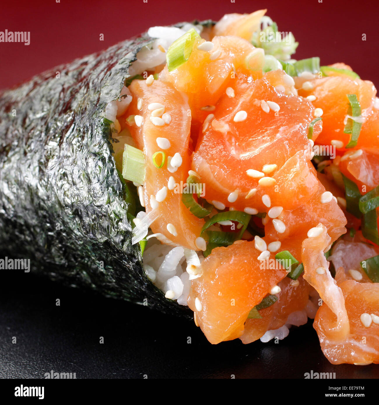 A close up of salmon temaki against a red background Stock Photo - Alamy