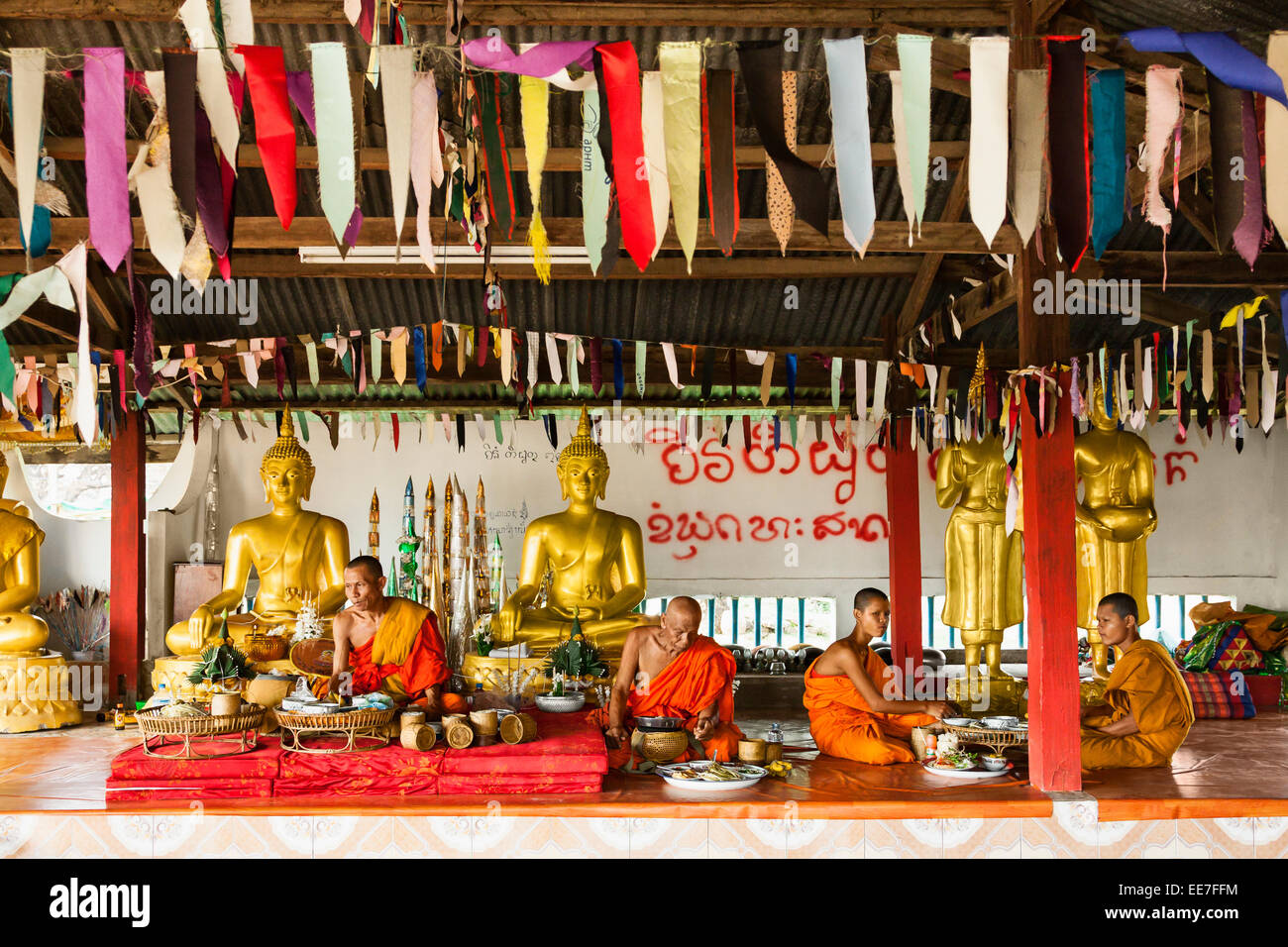 Buddhist monks having their lunch after devotions at small Lao temple ...