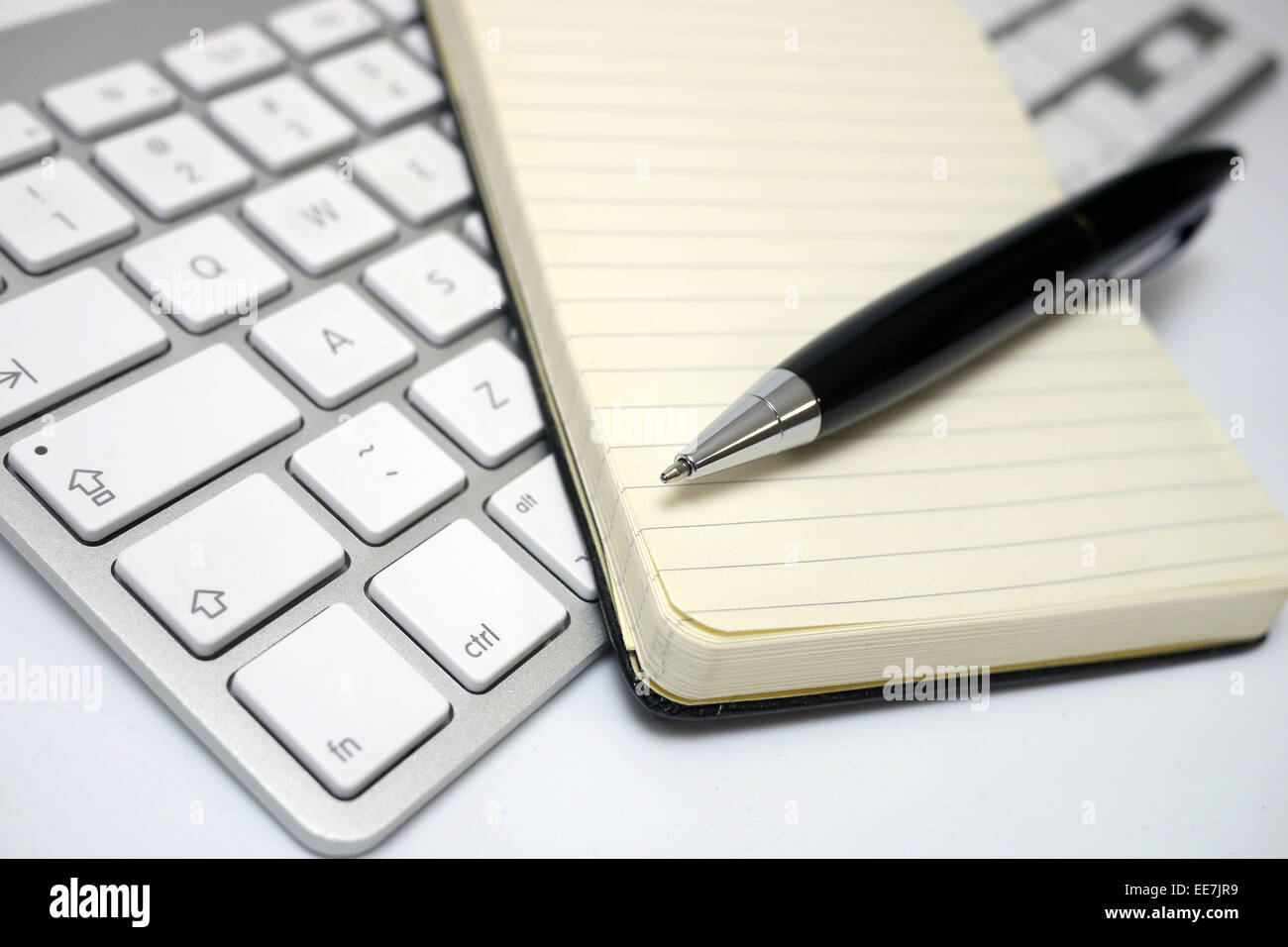 shallow focus on pen and notepad on keyboard Stock Photo - Alamy
