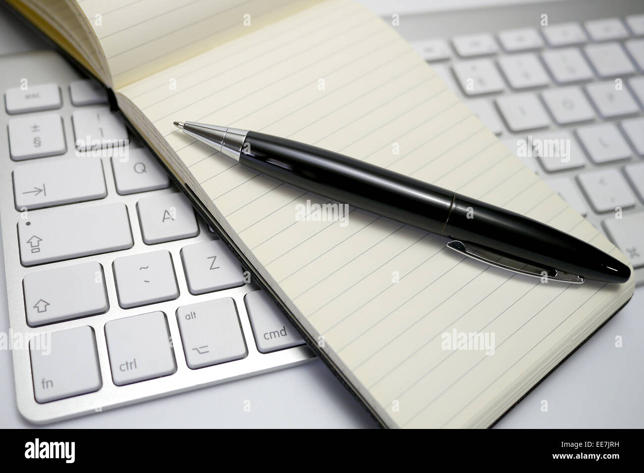 pen and notepad on keyboard Stock Photo - Alamy