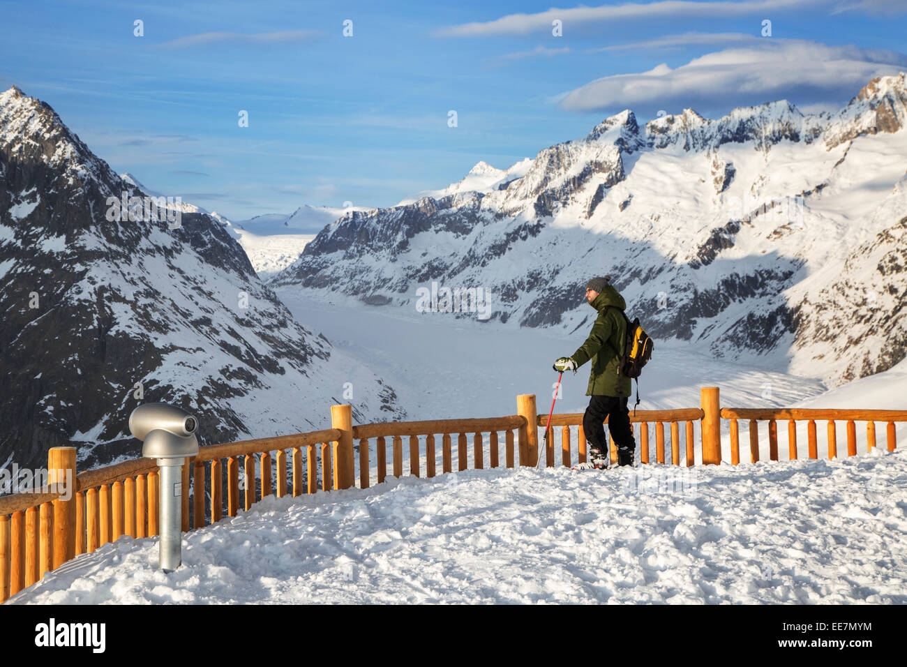 Tourist in the snow looking over the mountains in winter surrounding ...