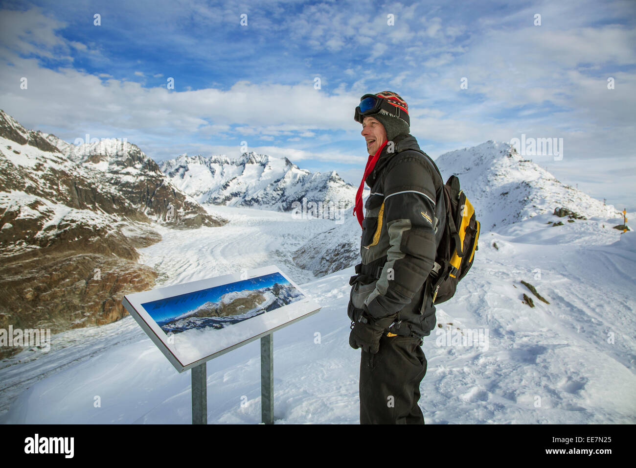 Tourist in the snow looking over the mountains in winter surrounding ...