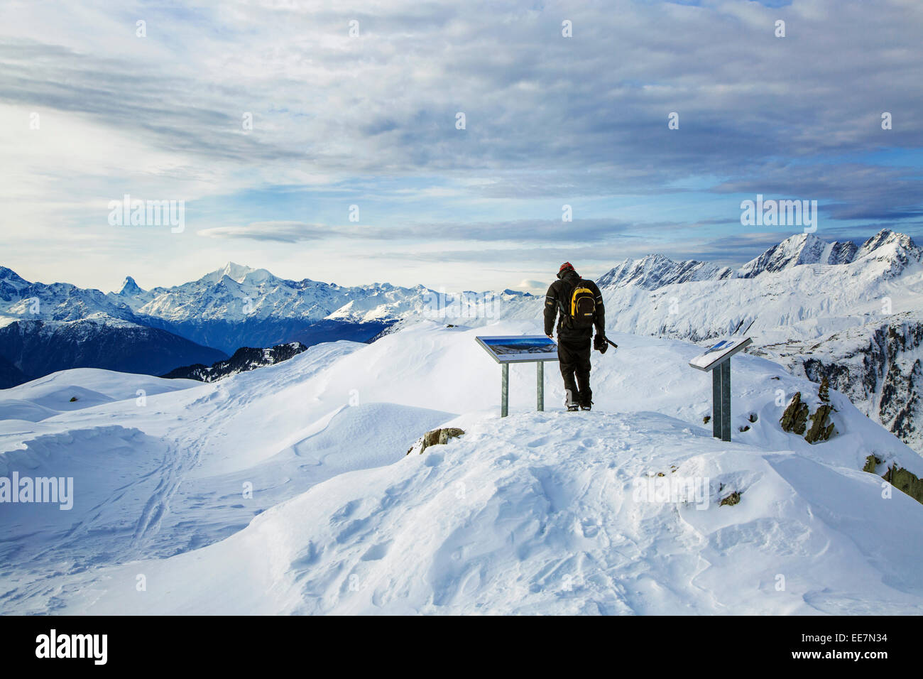 Tourist in the snow looking over the mountains in winter surrounding ...