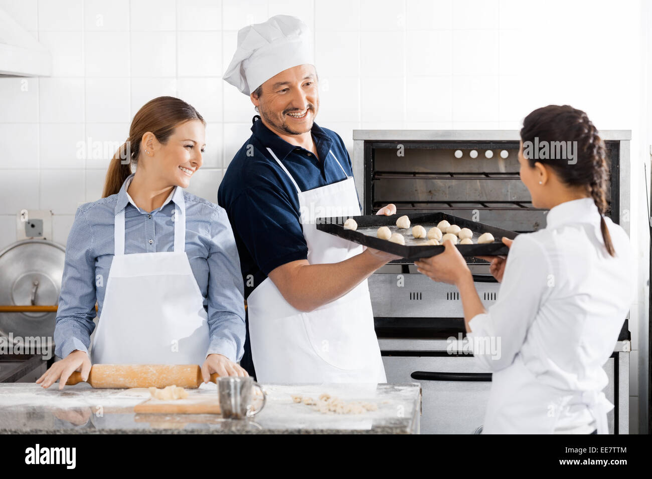Happy Chefs Baking At Commercial Kitchen Stock Photo - Alamy
