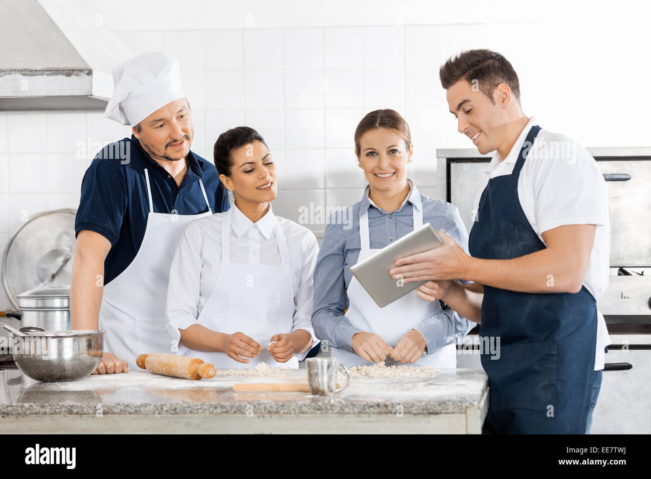 Chefs Checking Recipe On Tablet Computer In Kitchen Stock Photo - Alamy