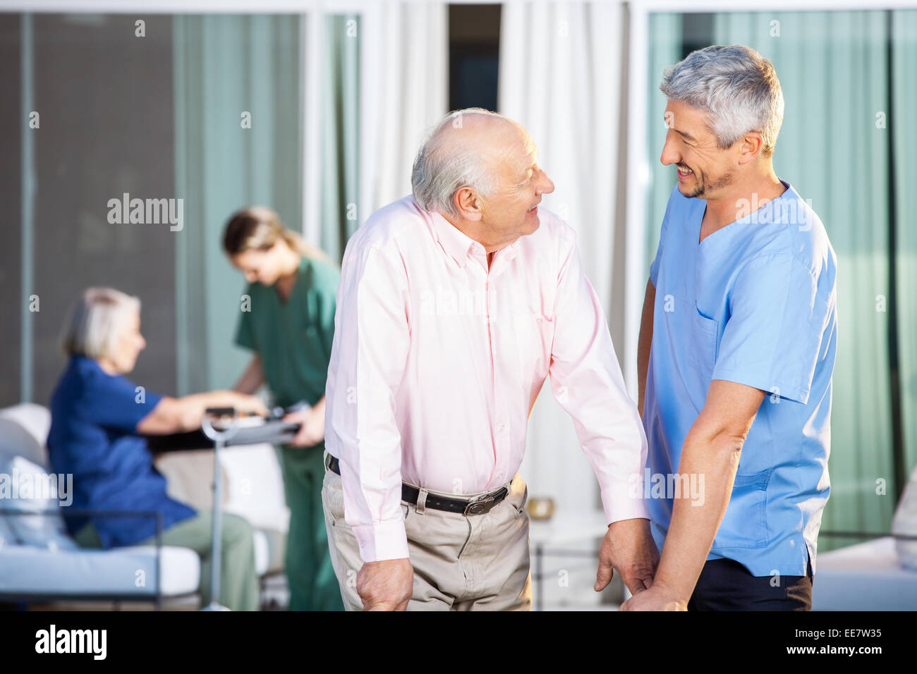 Happy Caretaker With Disabled Senior Man At Yard Stock Photo - Alamy