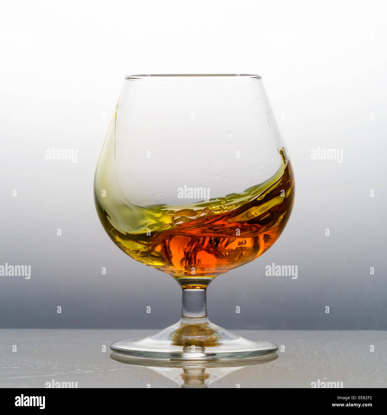 Square shot of cognac moving inside a glass Stock Photo - Alamy