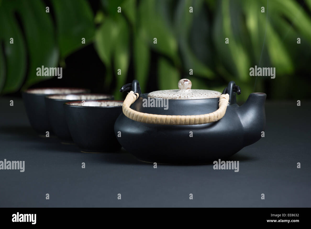 Black ceramic teapot with cups and steam Stock Photo - Alamy