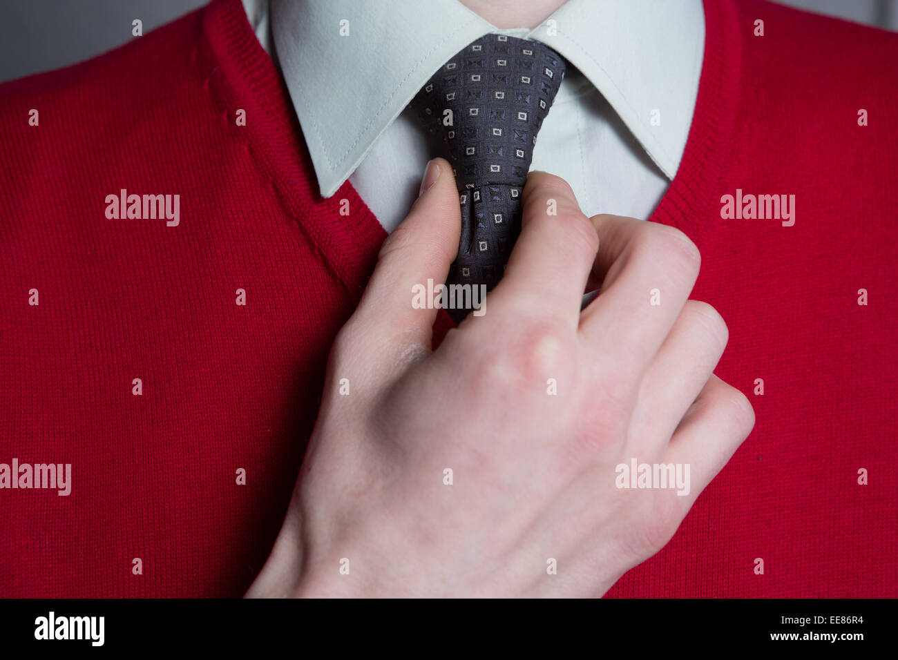 Man wearing white shirt with red sweater and necktie Stock Photo - Alamy