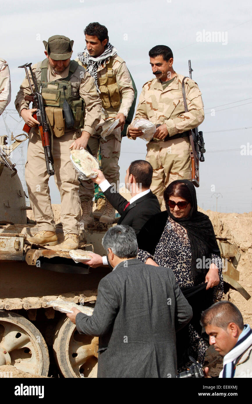 Kirkuk, Iraq. 14th Jan, 2015. Kurdish civilians hand foods to soldiers ...