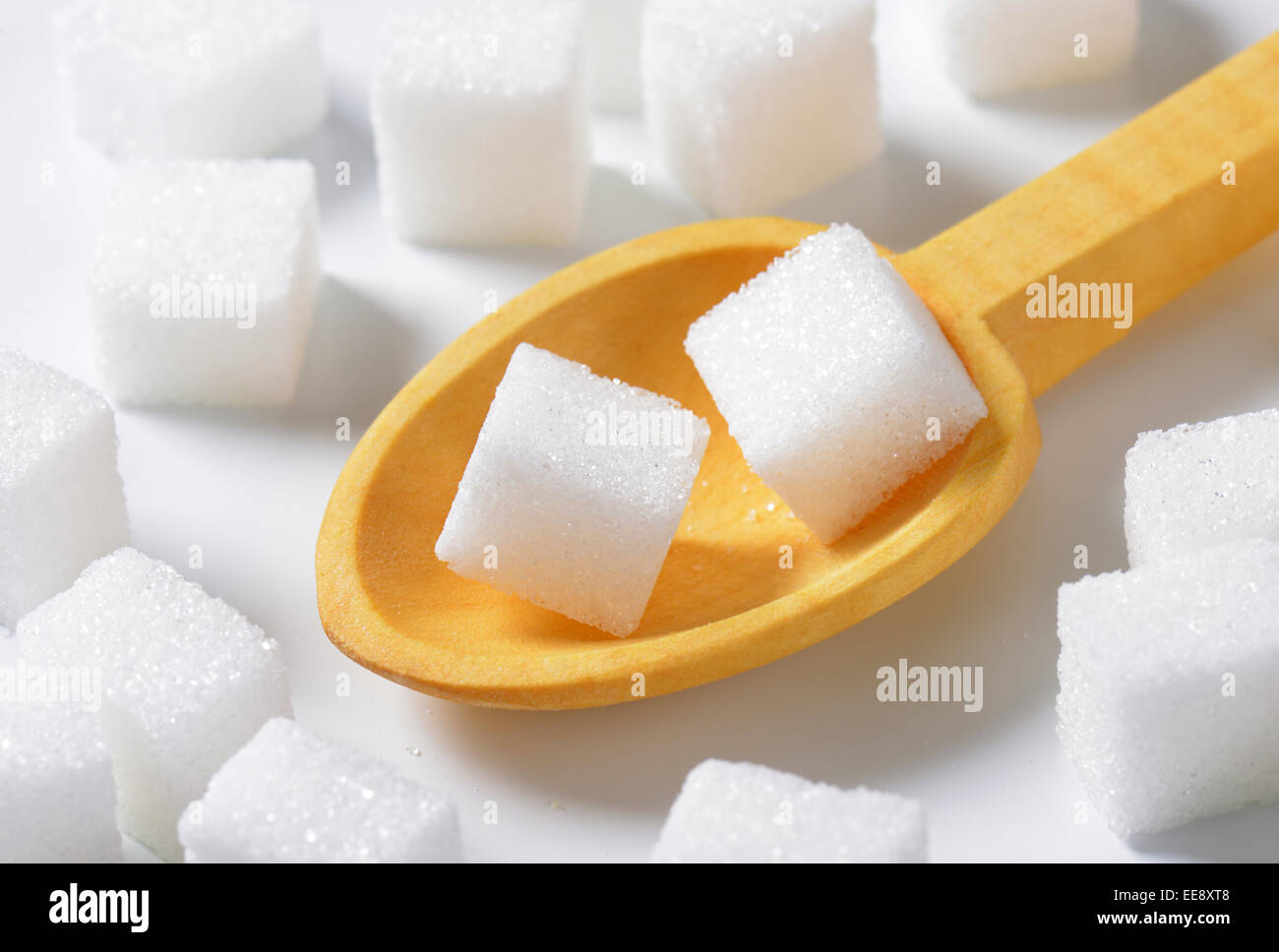 White sugar cubes and small wooden spoon Stock Photo - Alamy