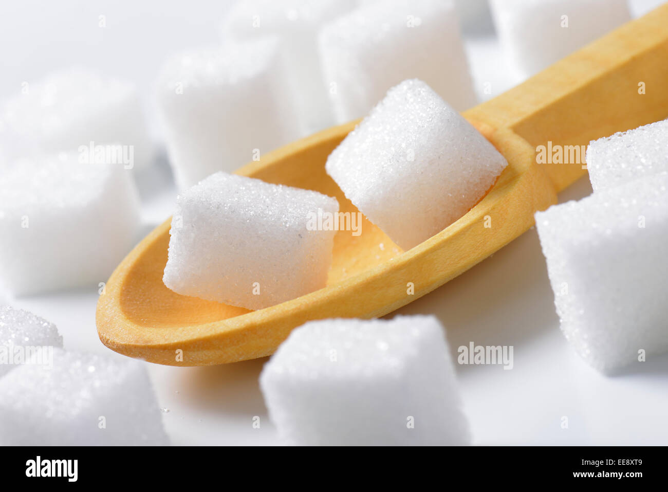 White sugar cubes and small wooden spoon Stock Photo - Alamy