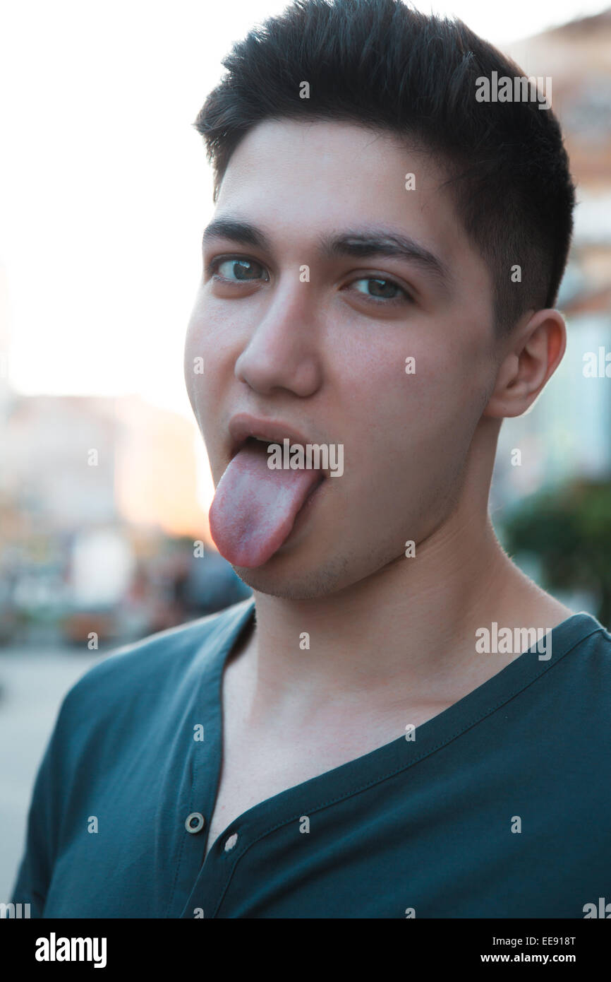 attractive young man showing his tongue Stock Photo - Alamy