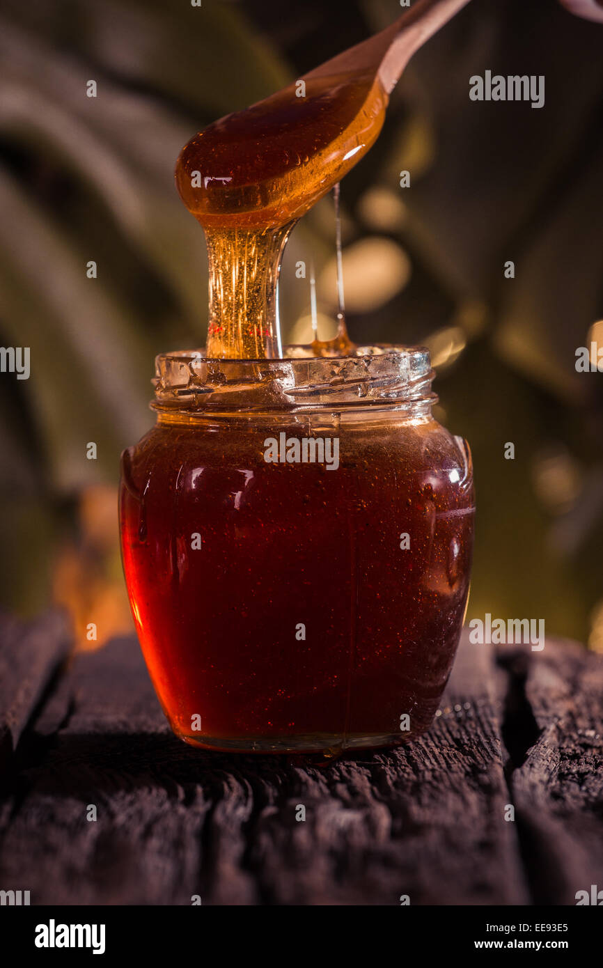 Honey drip in jar on the table Stock Photo - Alamy