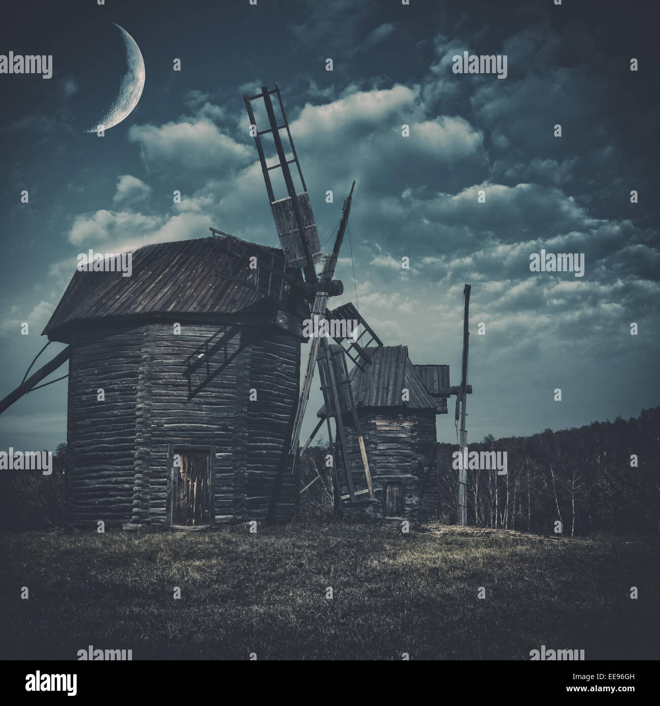 Spooky landscape with few haunted wind mills against dark forest and ...